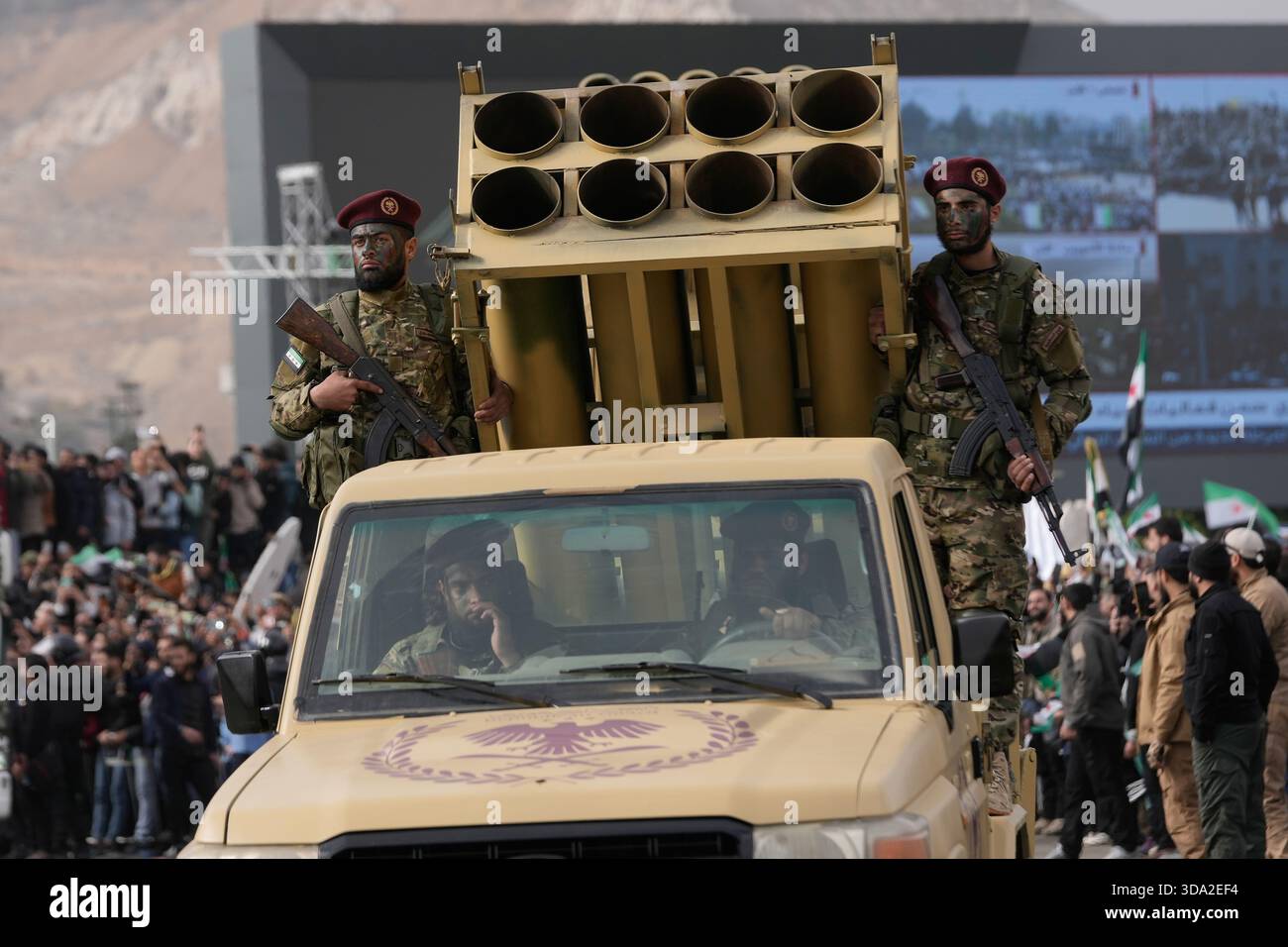 New Syrian army soldiers stand next to rocket launchers during a parade ...