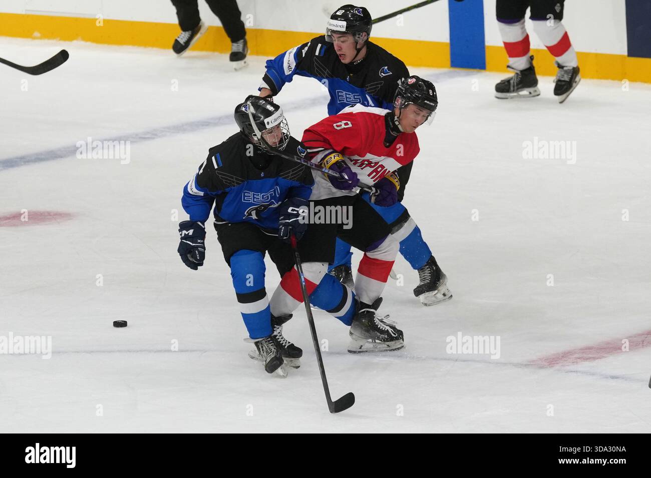 Japan's Reo Daikuhara, centre, battles for the puck with Estonia's ...