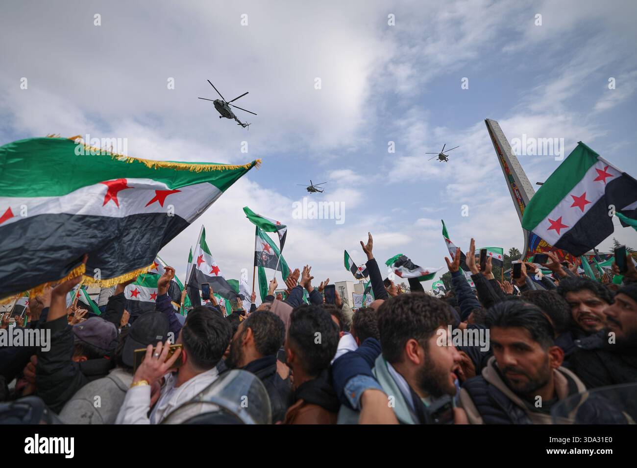 Army helicopters fly overhead during a parade by the new Syrian army ...