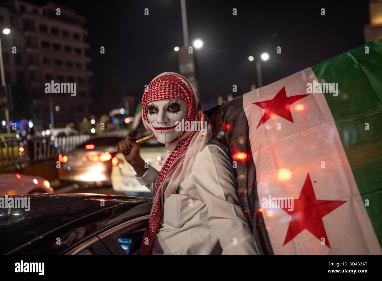 A man with a mask and the revolutionary flag on the streets of Damascus ...