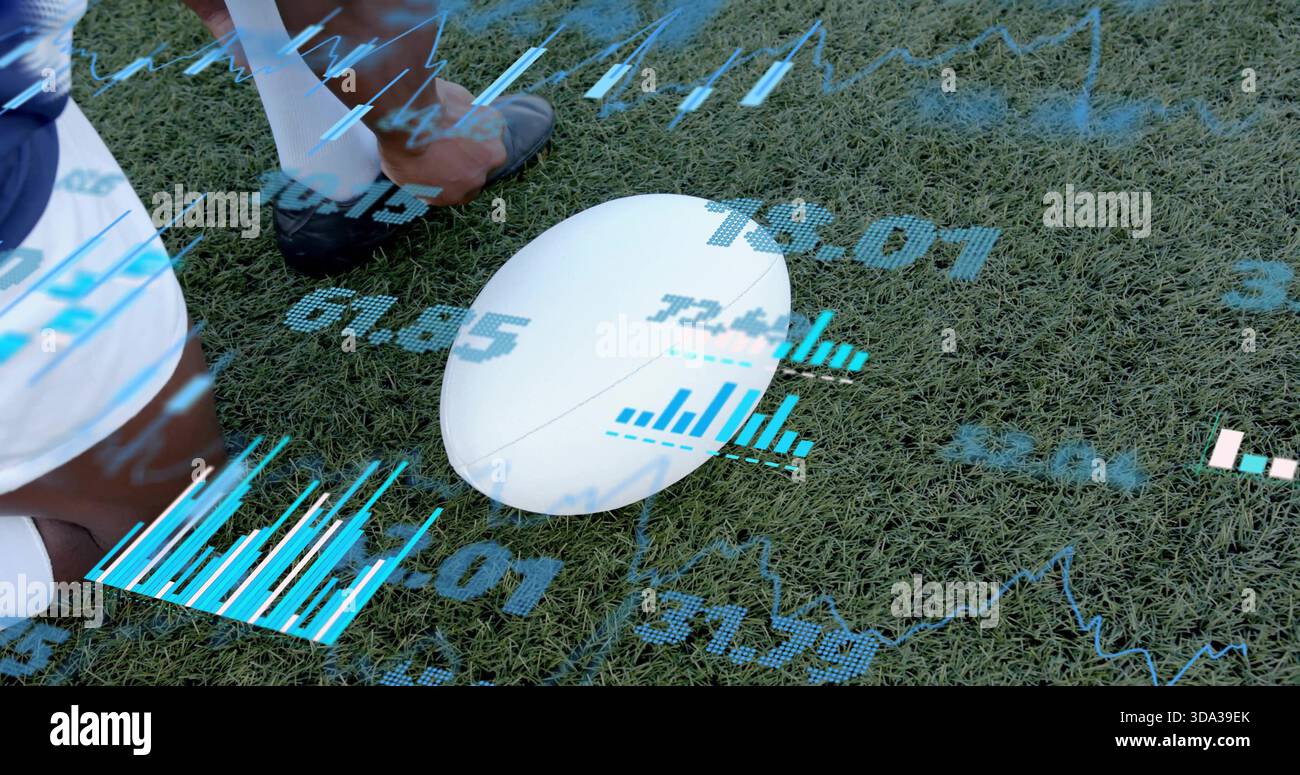 Kneeling athlete steadying white oval ball on grass pitch, wearing ...