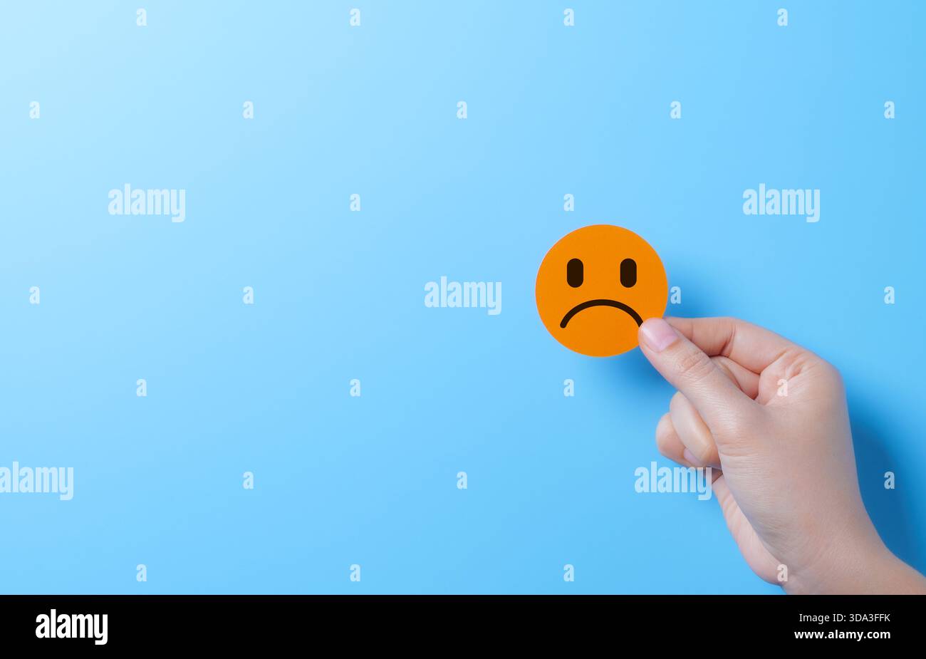 Sad Face Emoji Representing Negative Emotion. A hand holding sad face ...