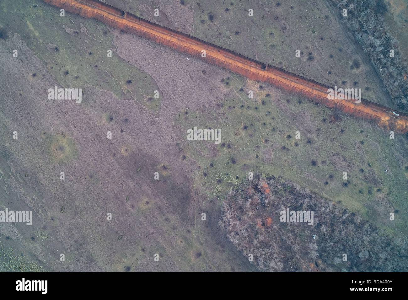 Aerial drone shot of a wide, straight infantry trench with bright ...