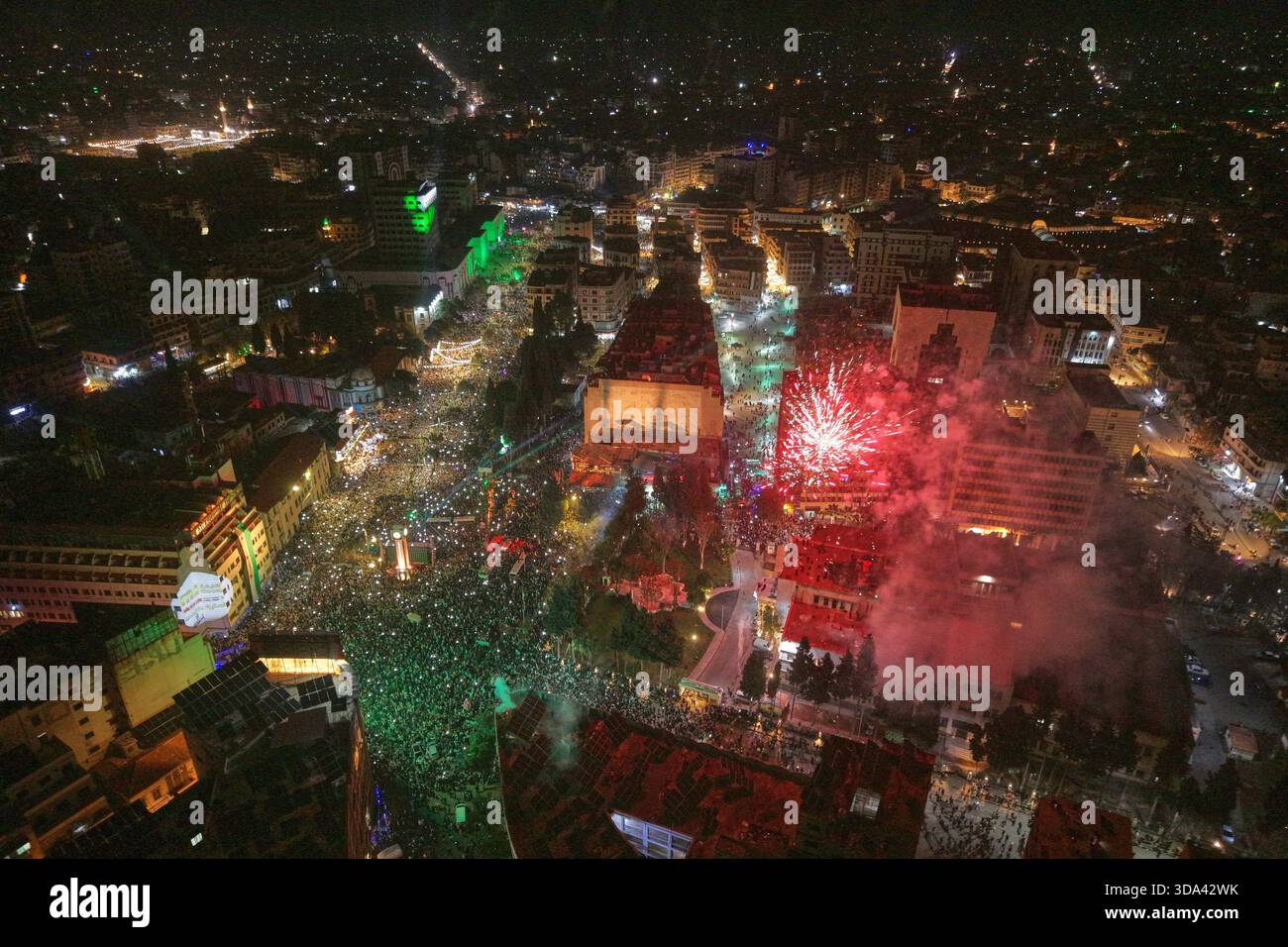 Fireworks and light beams illuminate the sky as people fill Clock ...