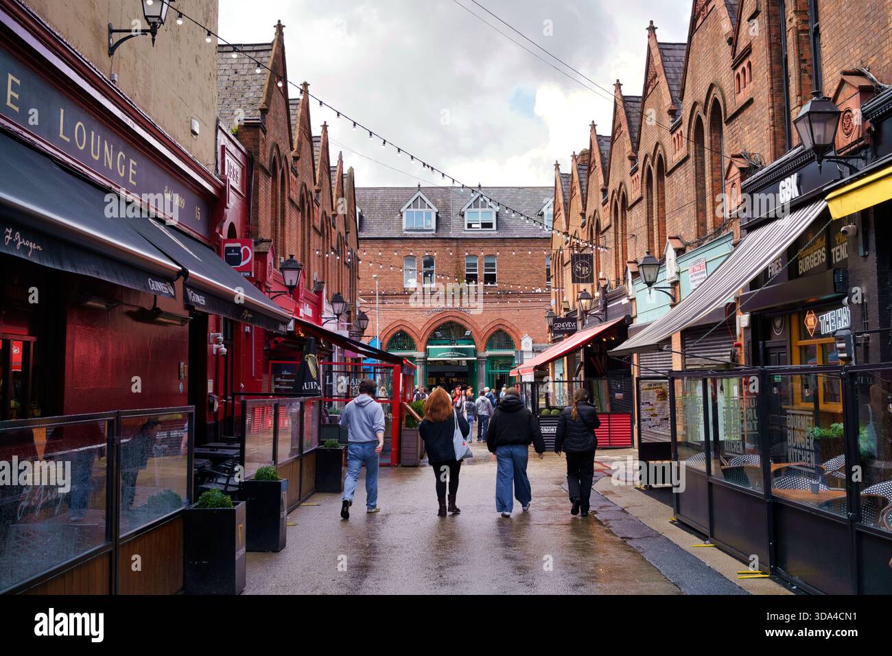 People walking in an urban street lined with shops and restaurants in ...