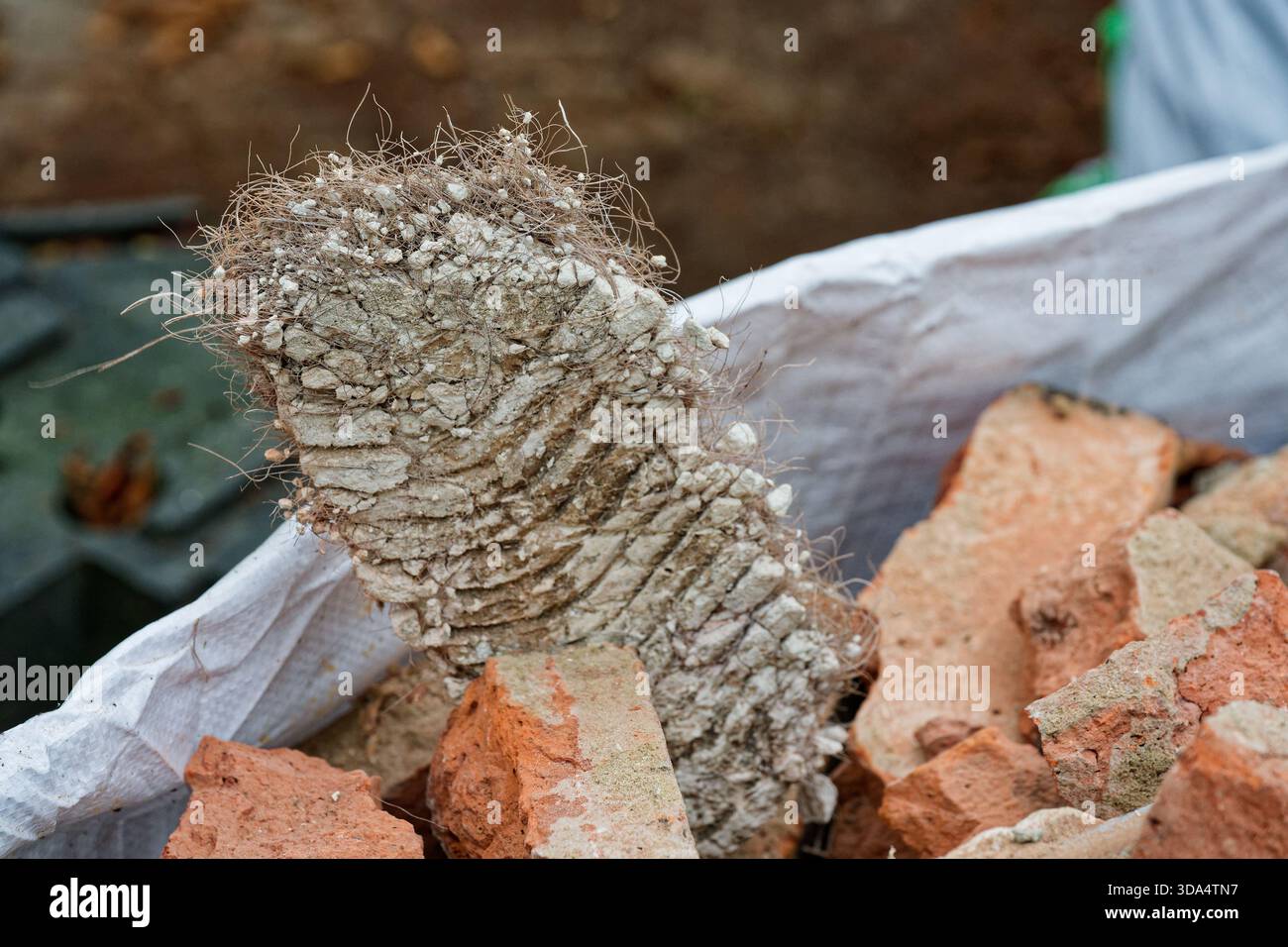 A heavy chunk of concrete sits torn from a wall with twisted metal ...