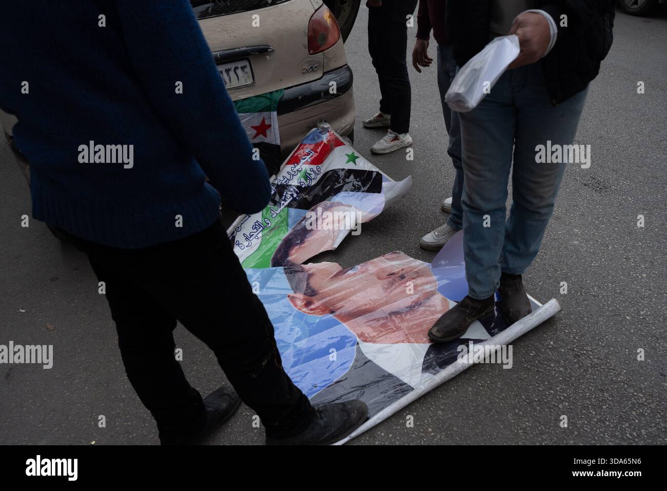 Syrians stamp on a poster of the former Syrian president Bashar al ...
