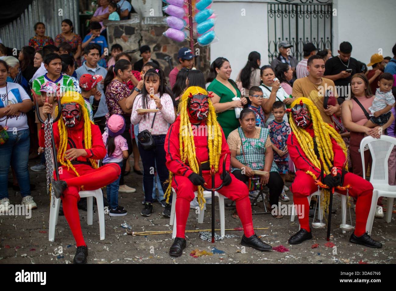 Men dressed as devils remain seated at the dance during the celebration ...