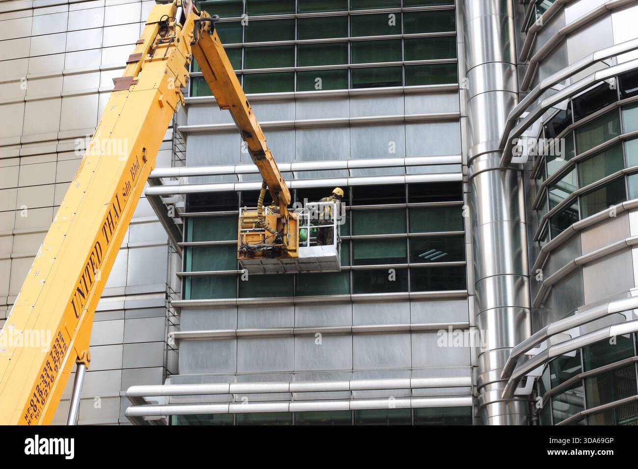 a worker using a crawler-mounted telescopic boom lift, specifically an ...