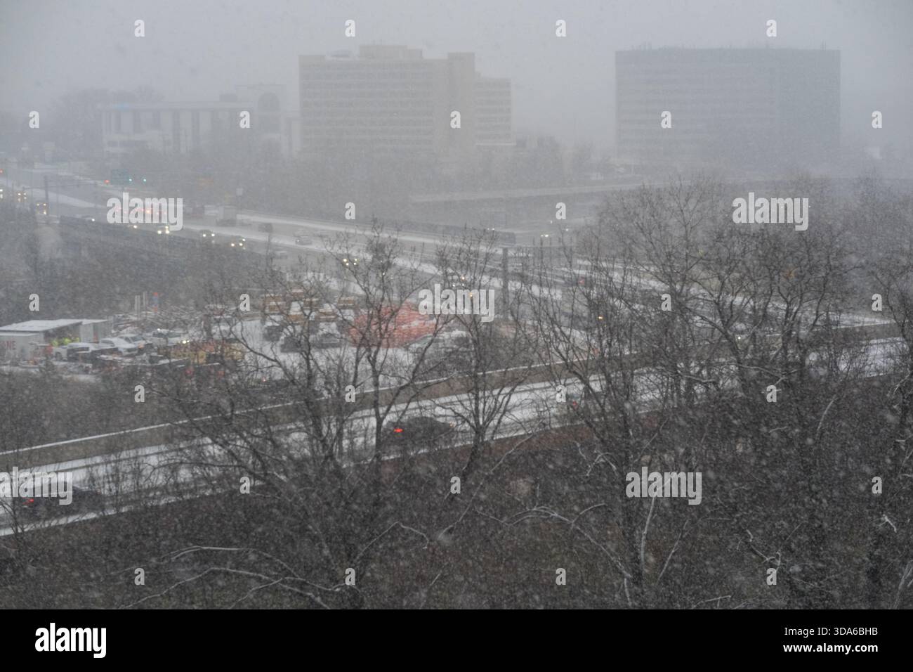 Winter snowstorm over highways, office buildings, and construction site ...
