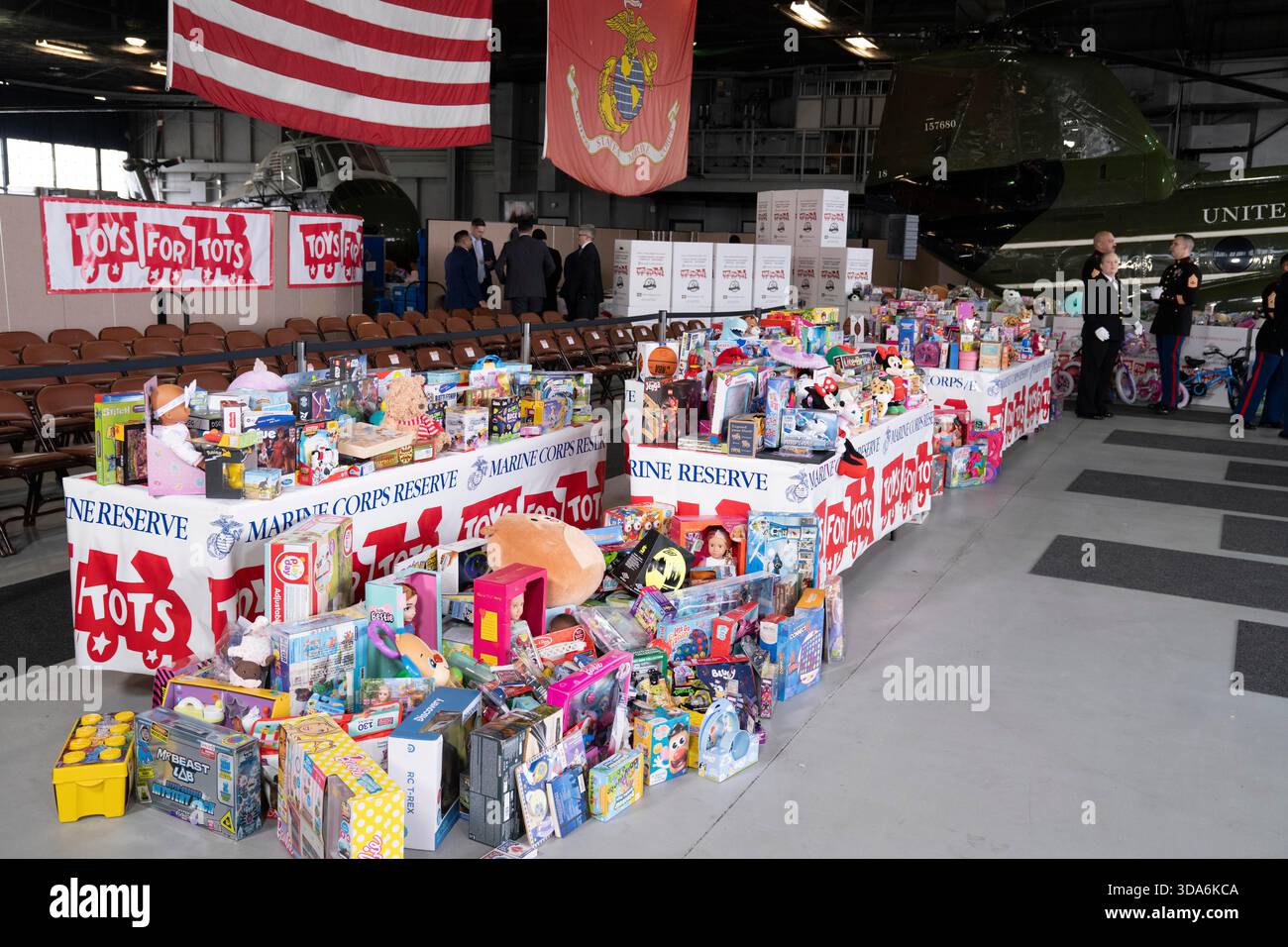 Tables of toys at charity drive for Toys for Tots with children and ...