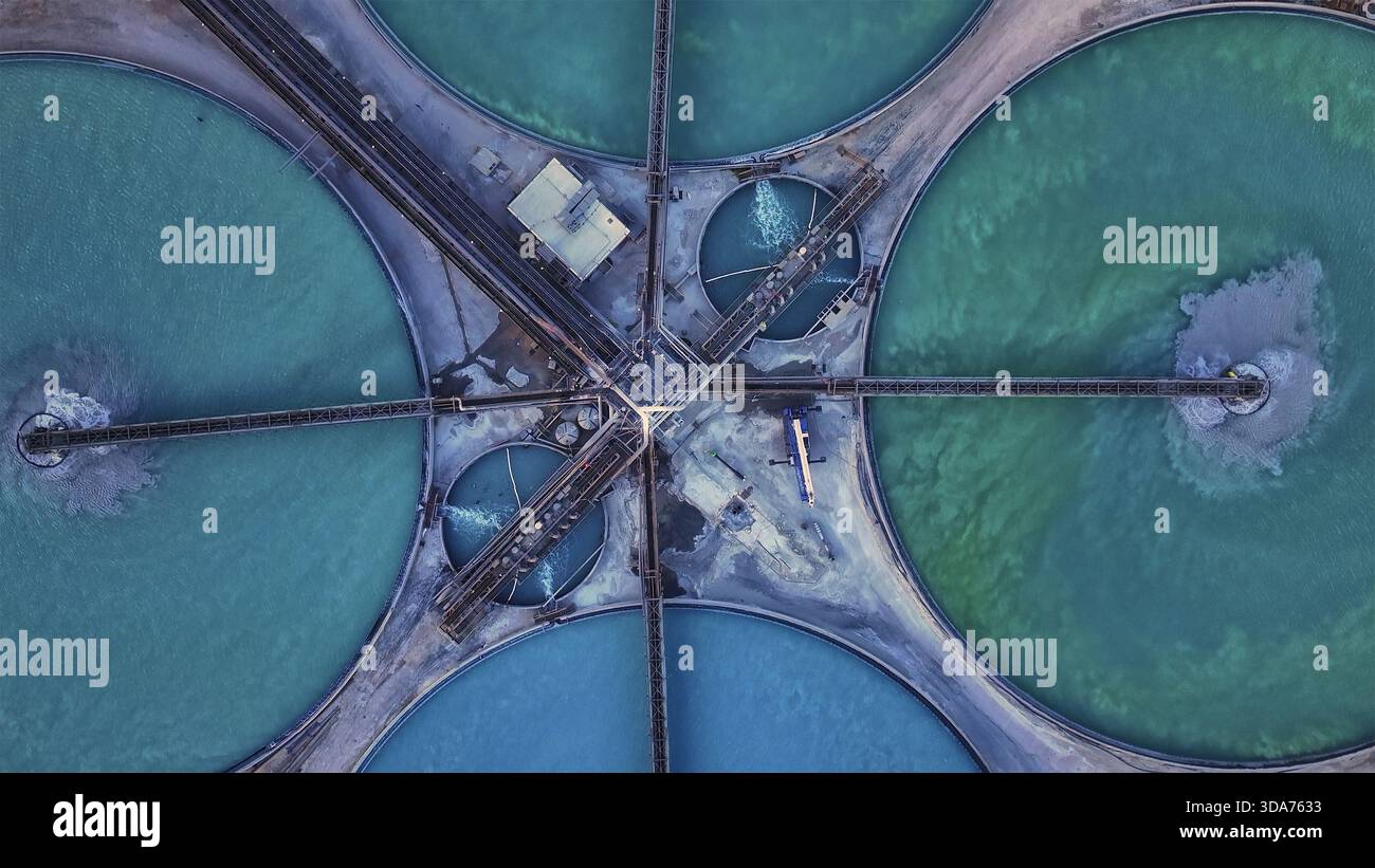 Aerial view of circular ponds with turquoise water and industrial ...