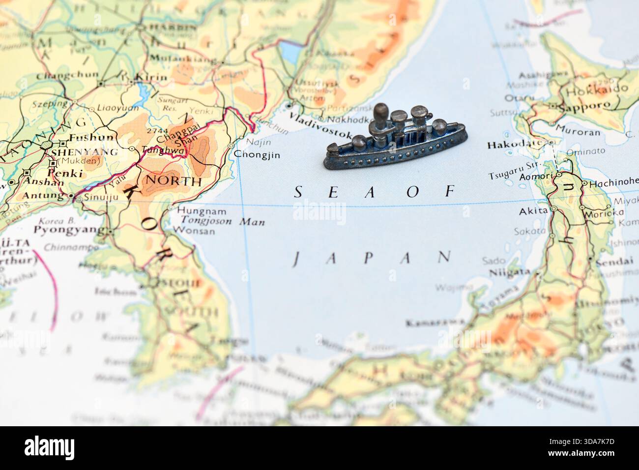 A toy battleship rests on a map of the Sea of Japan, symbolizing naval ...