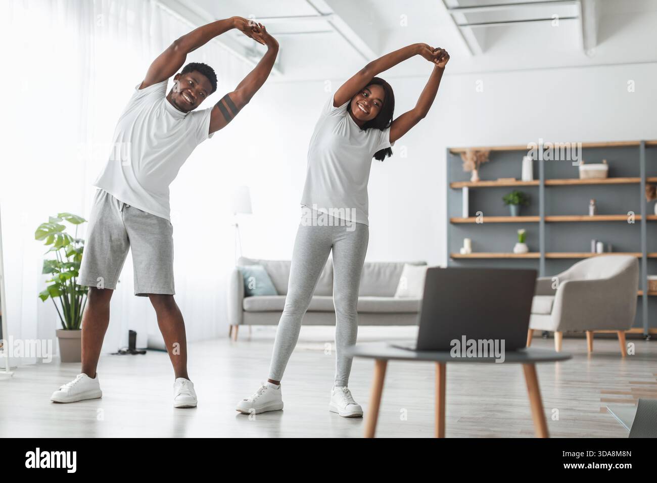 Young black couple doing side bend exercise using pc Stock Photo - Alamy