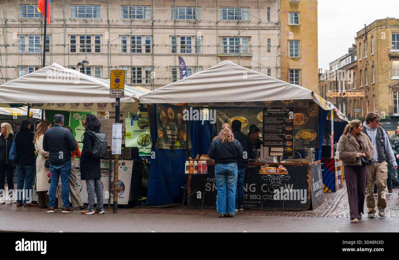 People queueing at food stalls and walking past street food market in ...