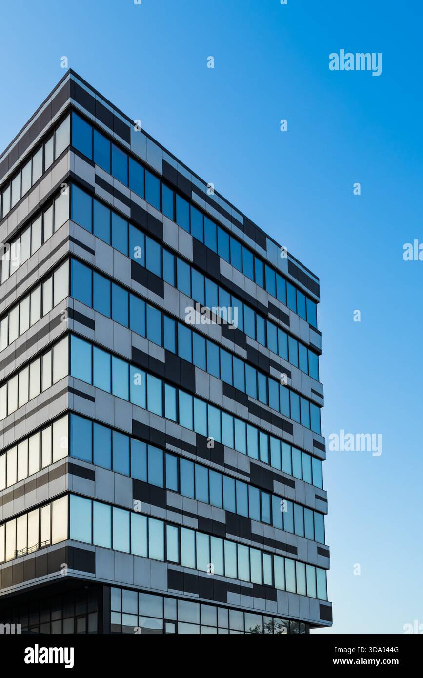 Contemporary glass office building with angular wall accents and rich ...