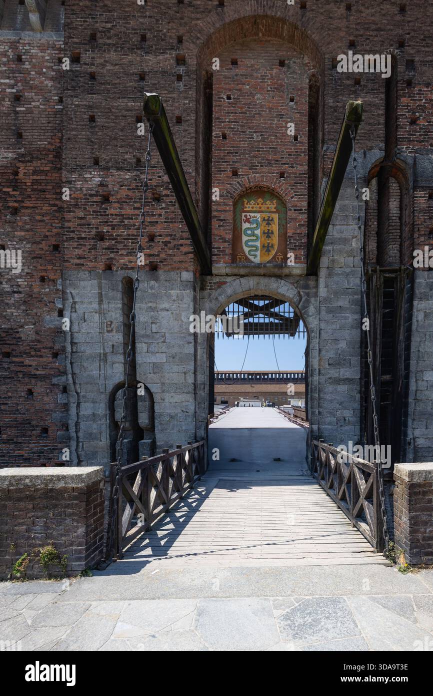 A medieval brick fortress entrance features a wooden suspension ...