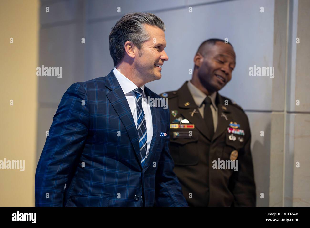 Defense Secretary Pete Hegseth smiles as he walks to a secure room in ...