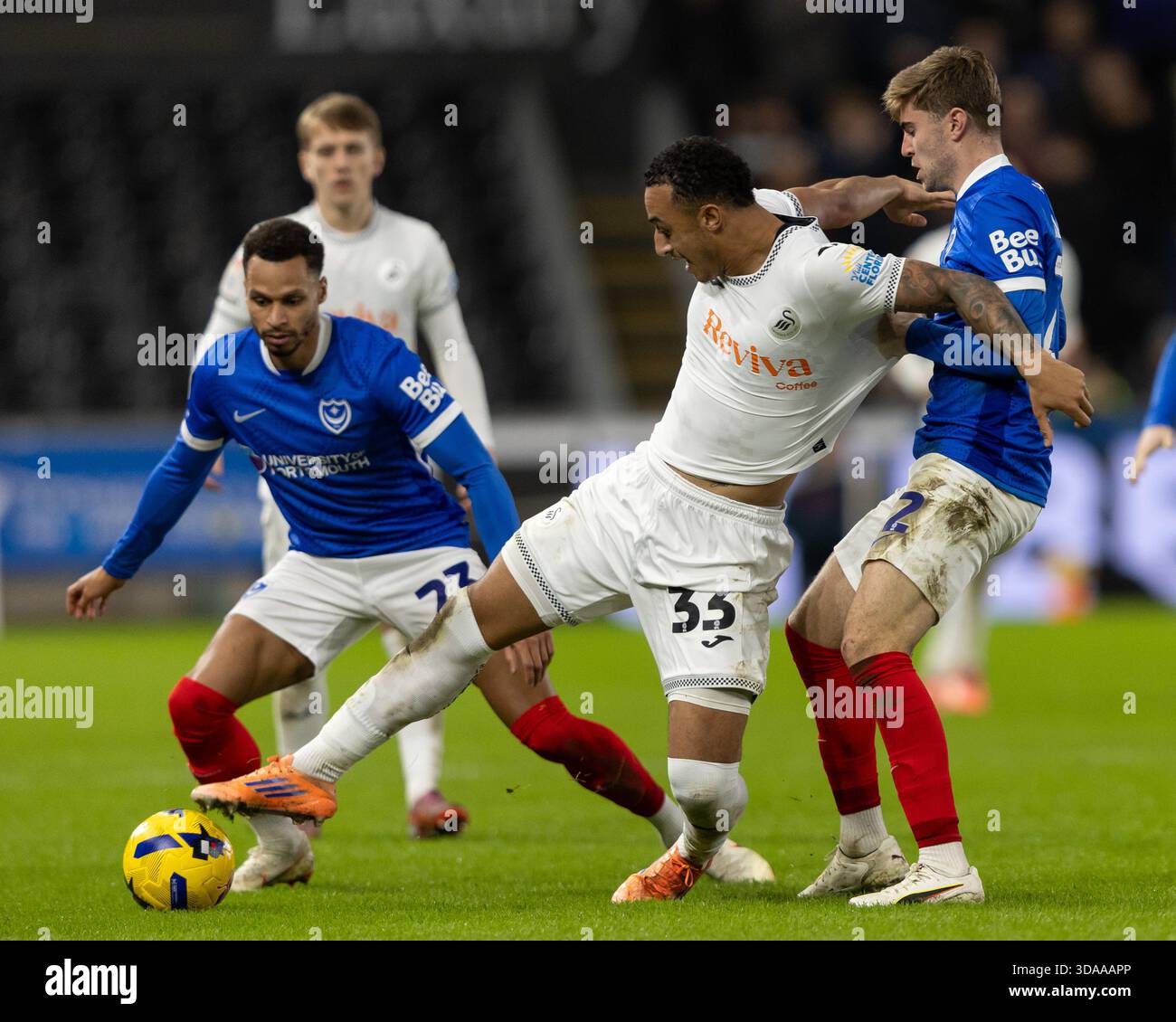 Zak Swanson of Portsmouth pulls the shirt of Adam Idah of Swansea City ...