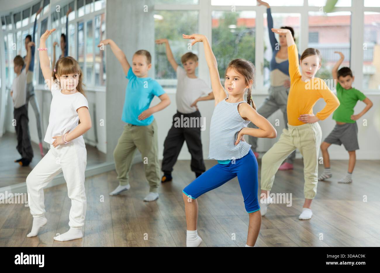 Children training modern dance moves together in studio under the ...