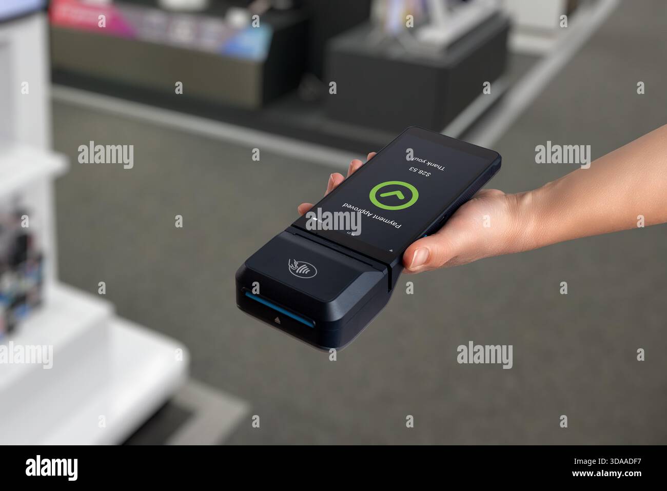Hand holding POS terminal in electronics store, showing payment ...