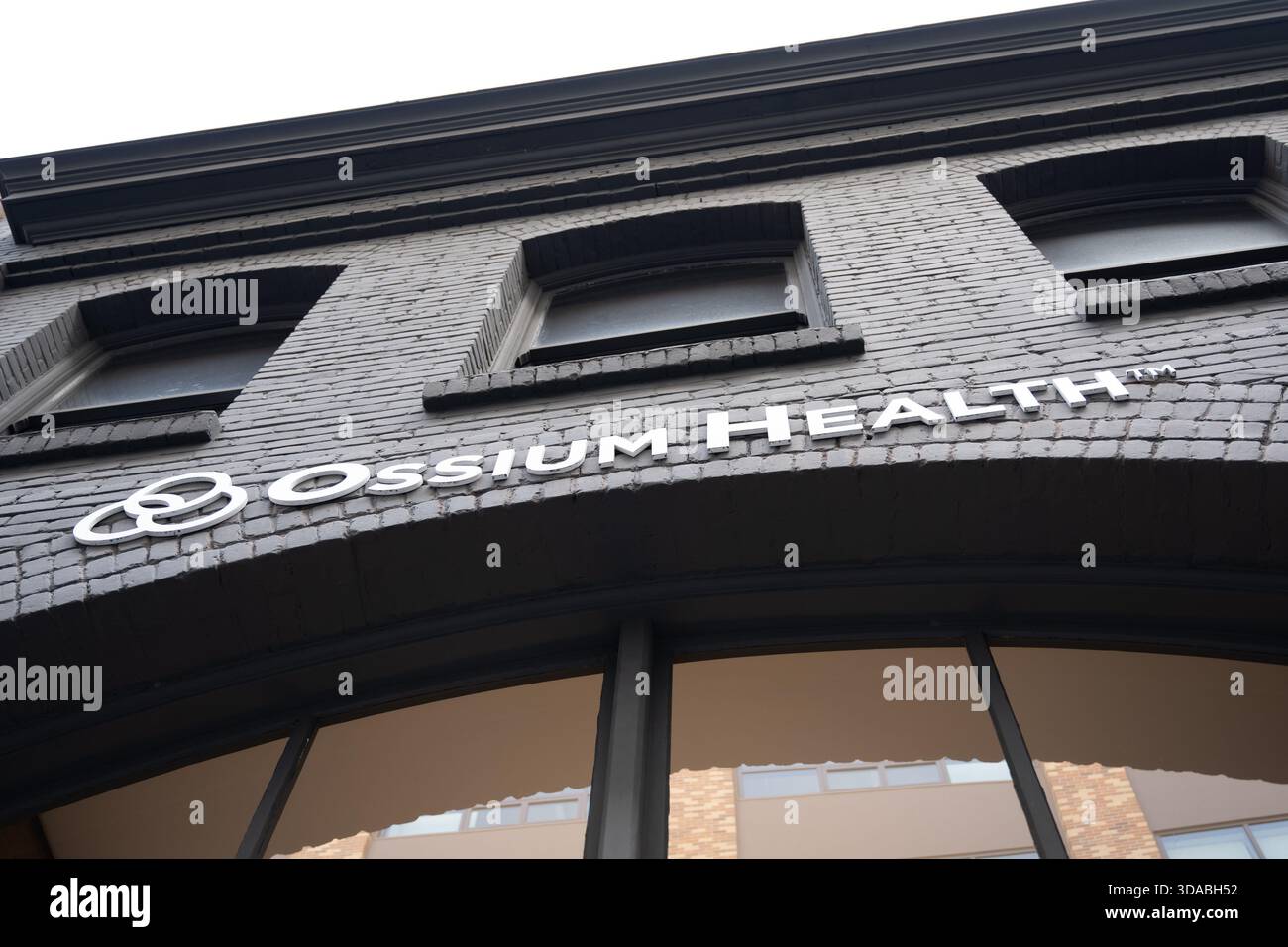 Low-angle view of Ossium Health logo on brick building facade, San ...