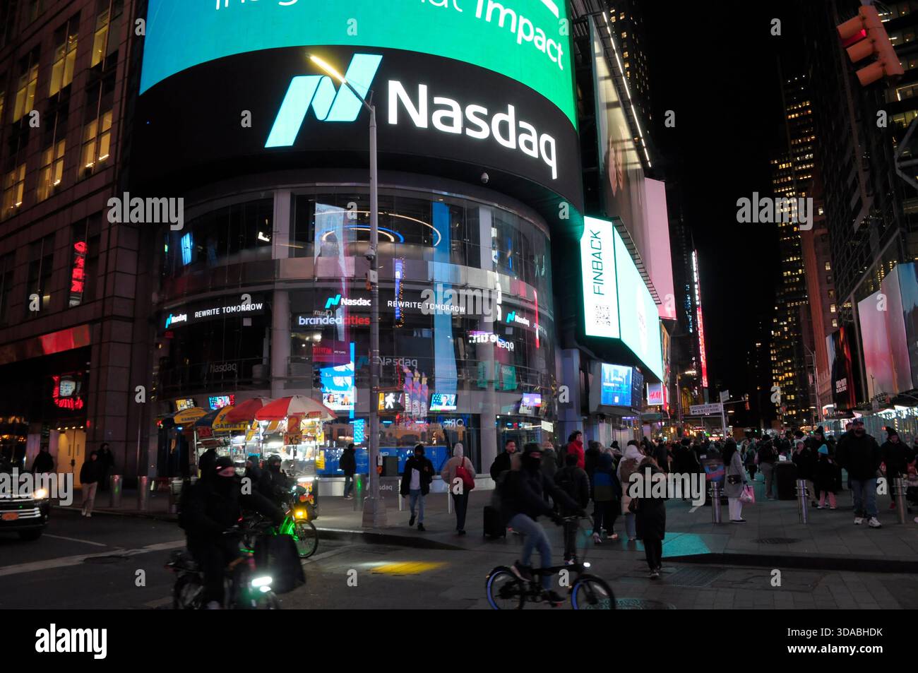 People walk past the Nasdaq MarketSite Times Square event space in ...