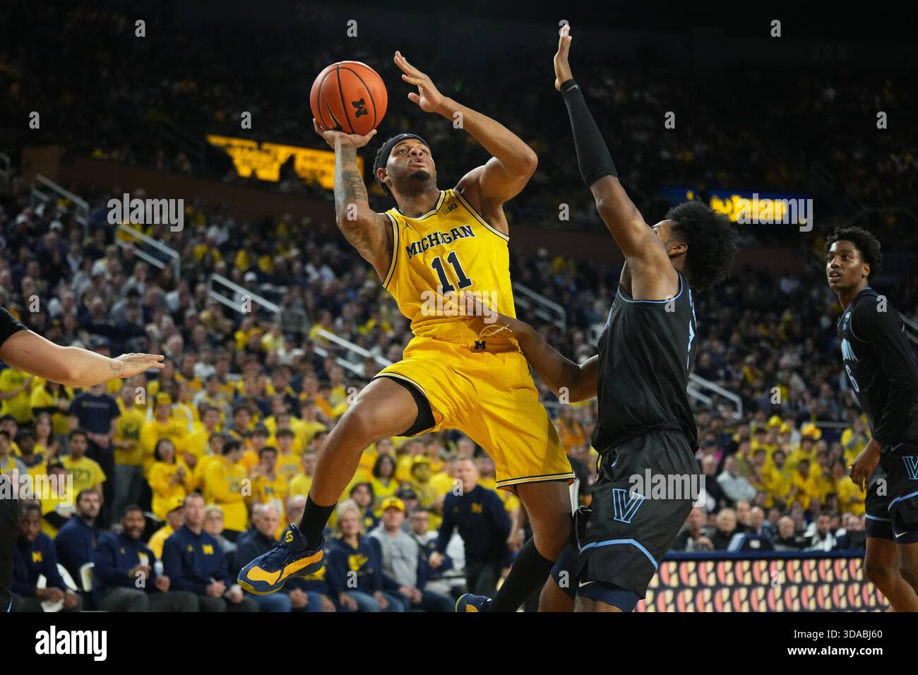 Michigan guard Roddy Gayle Jr., left, shoots against Villanova guard ...