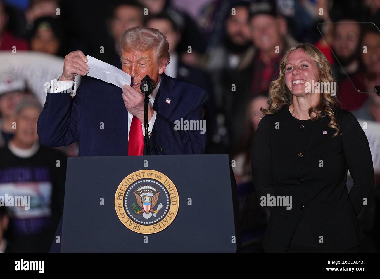 President Donald Trump looks at the speech notes of a local resident ...