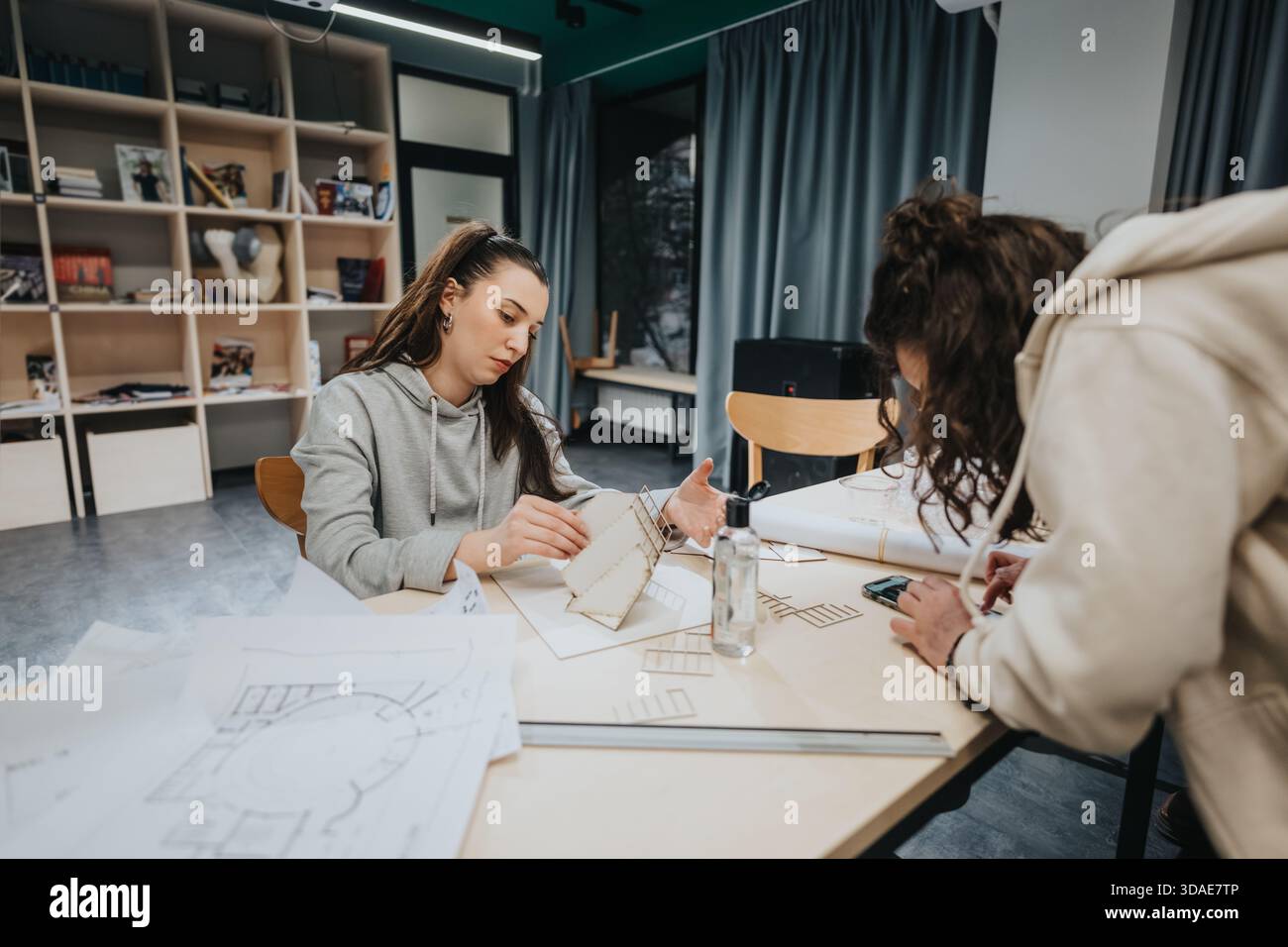 Two design students collaborate at a modern studio, reviewing sketches ...