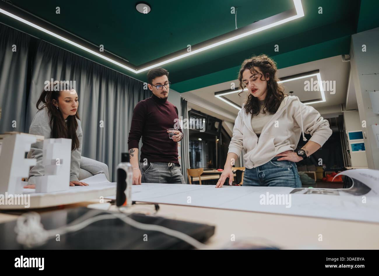 Students collaborate in a modern center planning project around a large ...