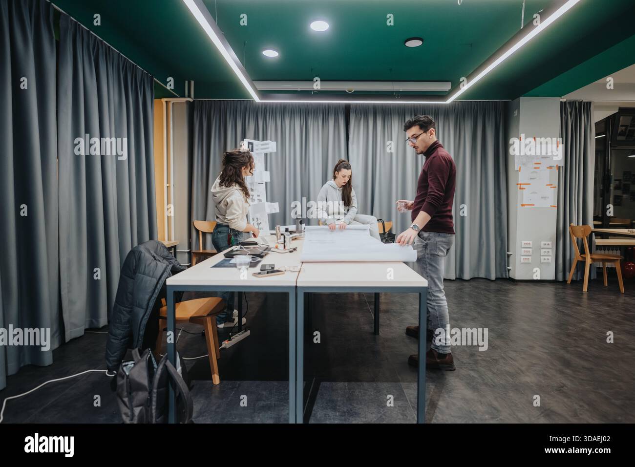 Students collaborate at a modern collaboration center planning designs ...