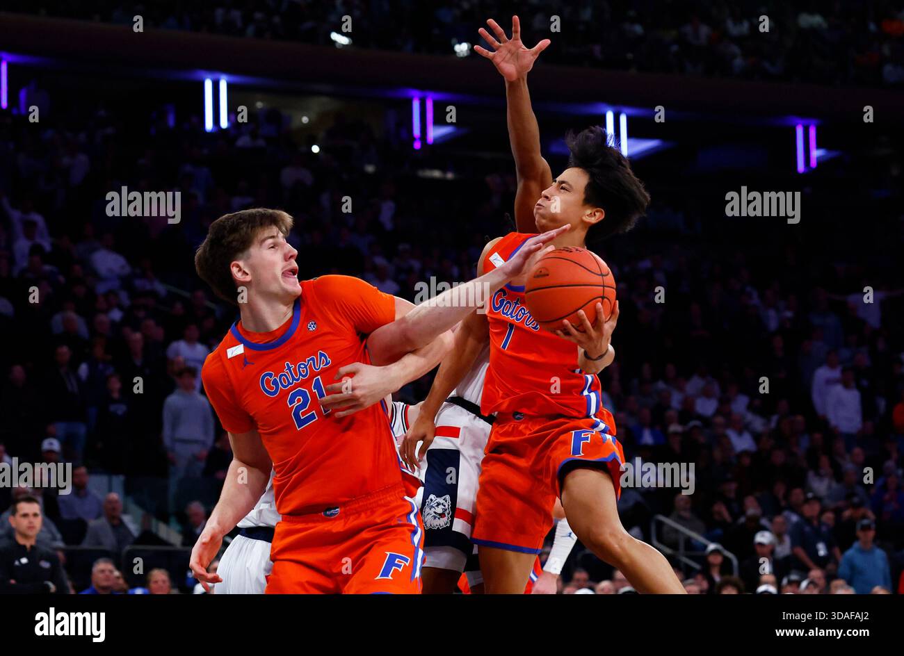 UConn forward Alex Karaban reaches through the arm of Florida forward ...