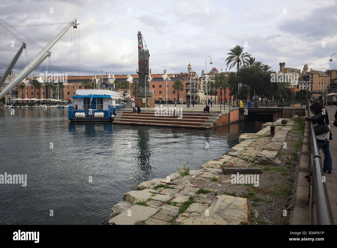 Genova, Italy - 14TH NOVEMBER 2025 - Boat moored next to an old crane ...