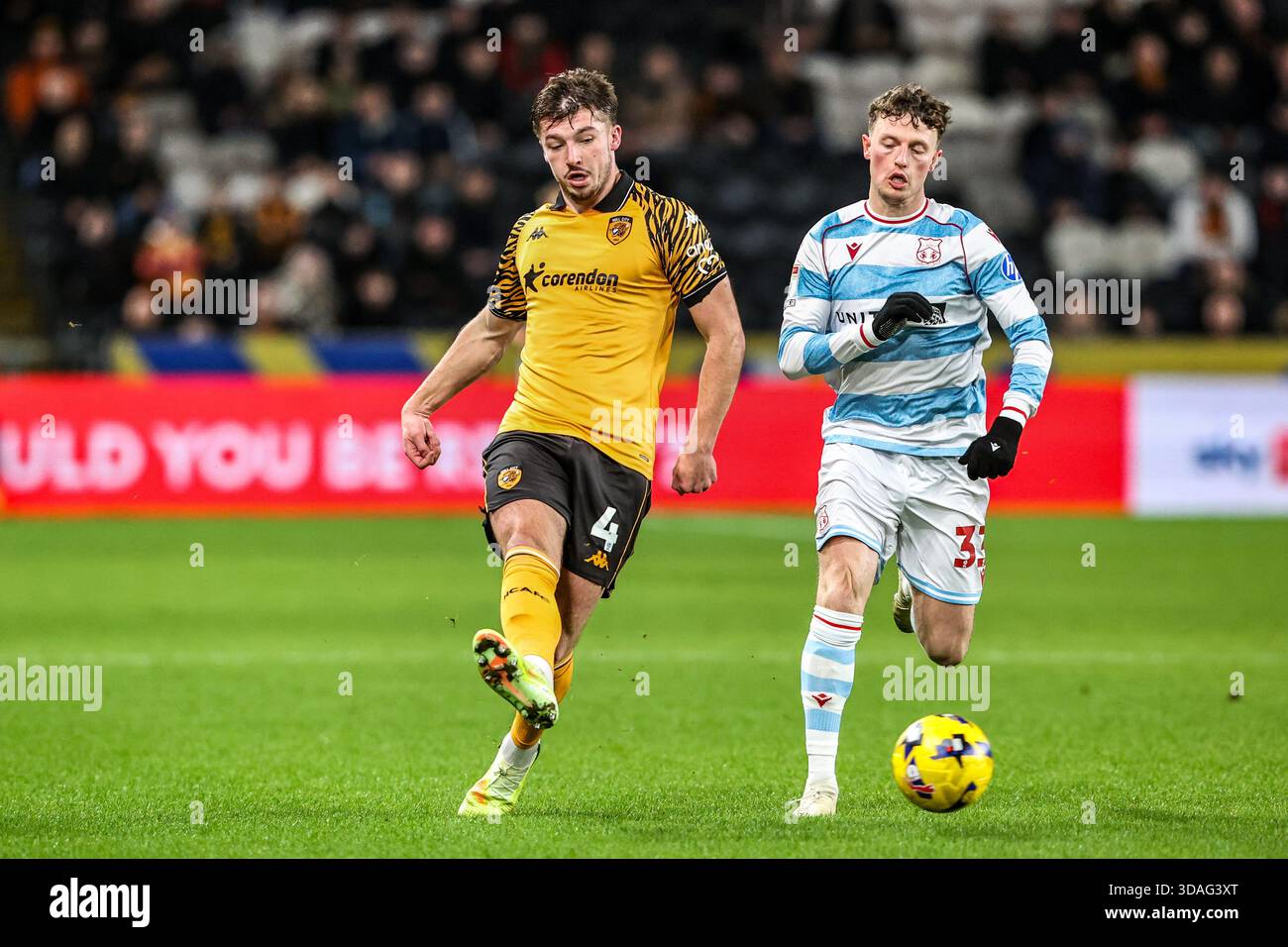 Charlie Hughes of Hull City passes the ball under pressure from Nathan ...