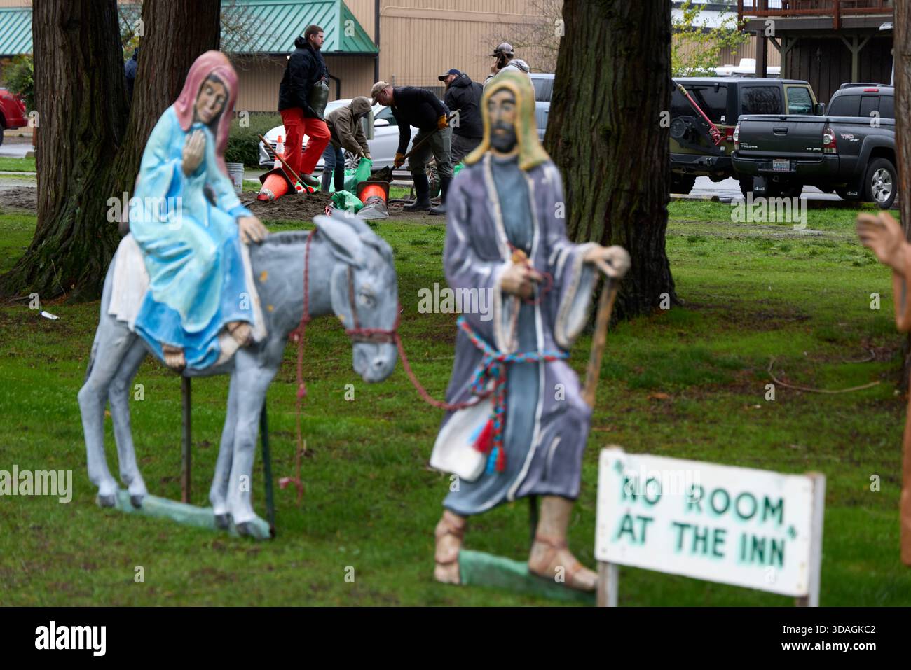 Residents and volunteer fill sand bags behind a Nativity scene to help ...