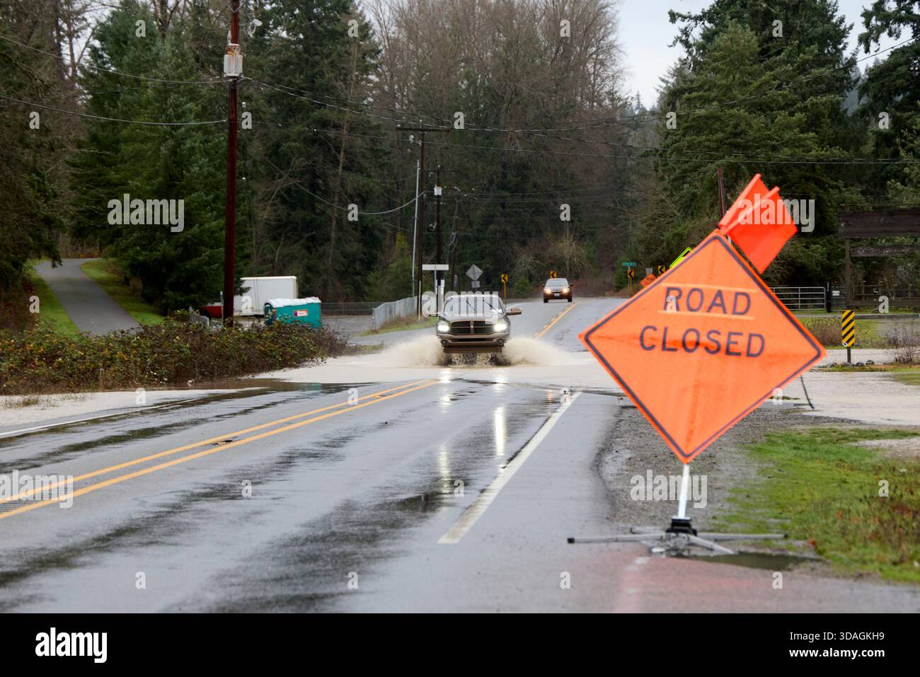 A pickup truck drives through flooding waters on Wash. Hwy. 162 ...