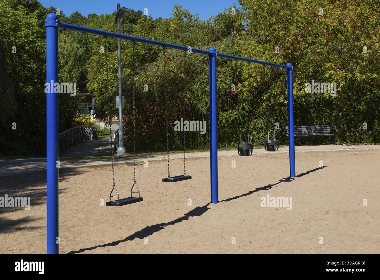 Swings installed in sandy ground in kids playground in city park in ...