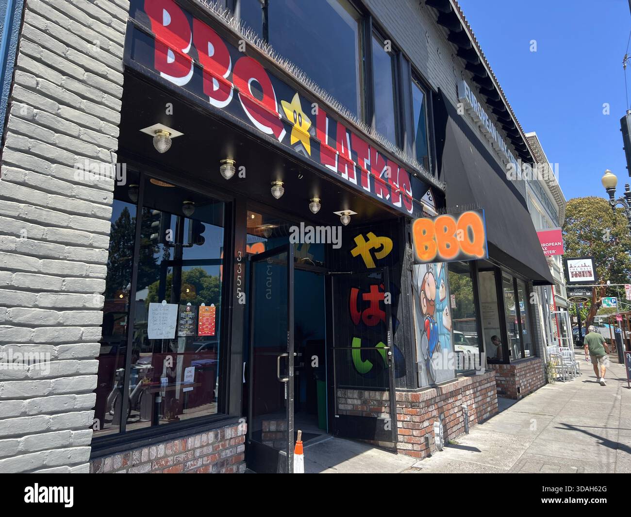Facade of a barbecue restaurant with colorful signage and a brick ...