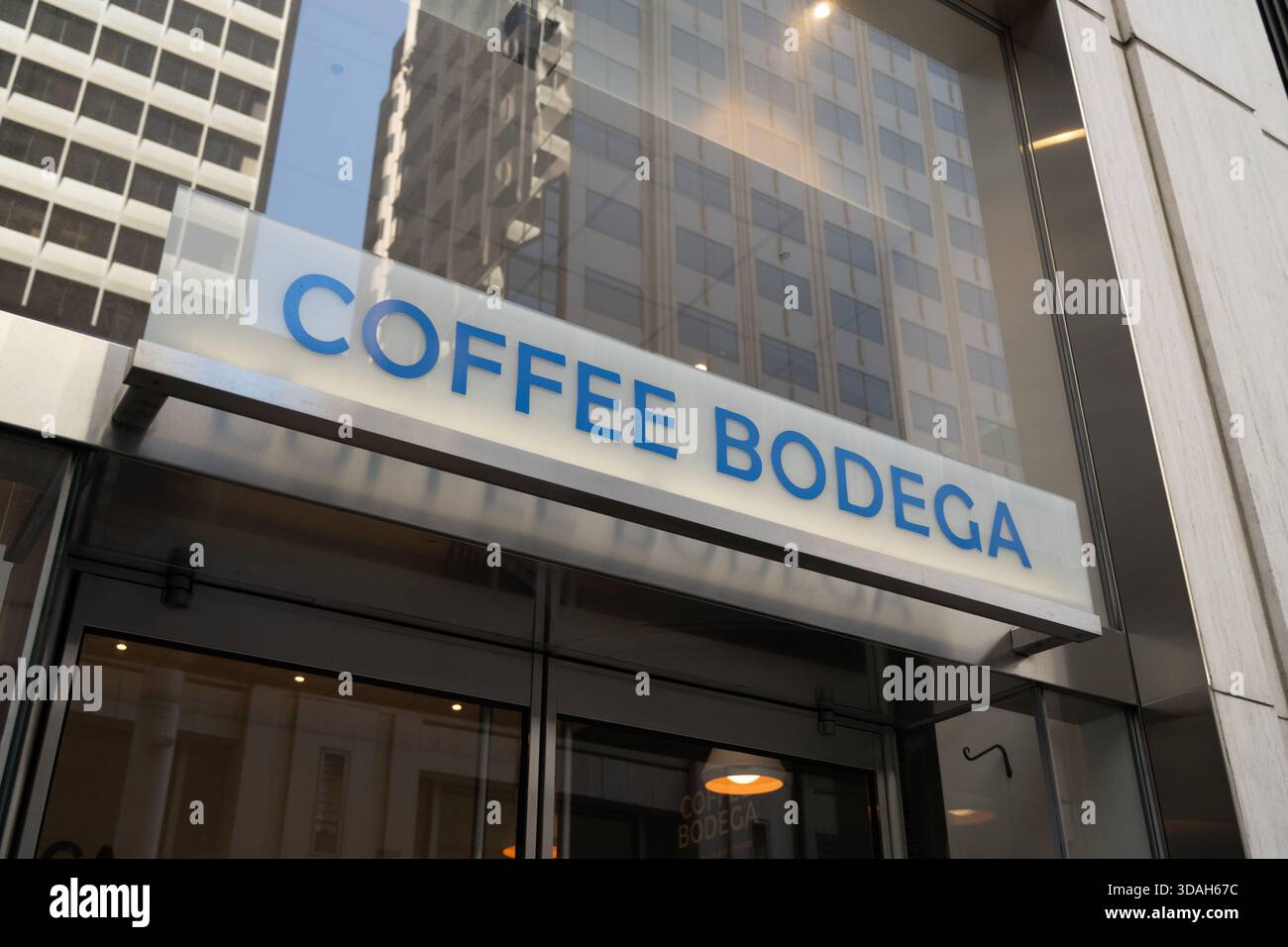 Exterior of Coffee Bodega cafe with illuminated sign and glass facade ...