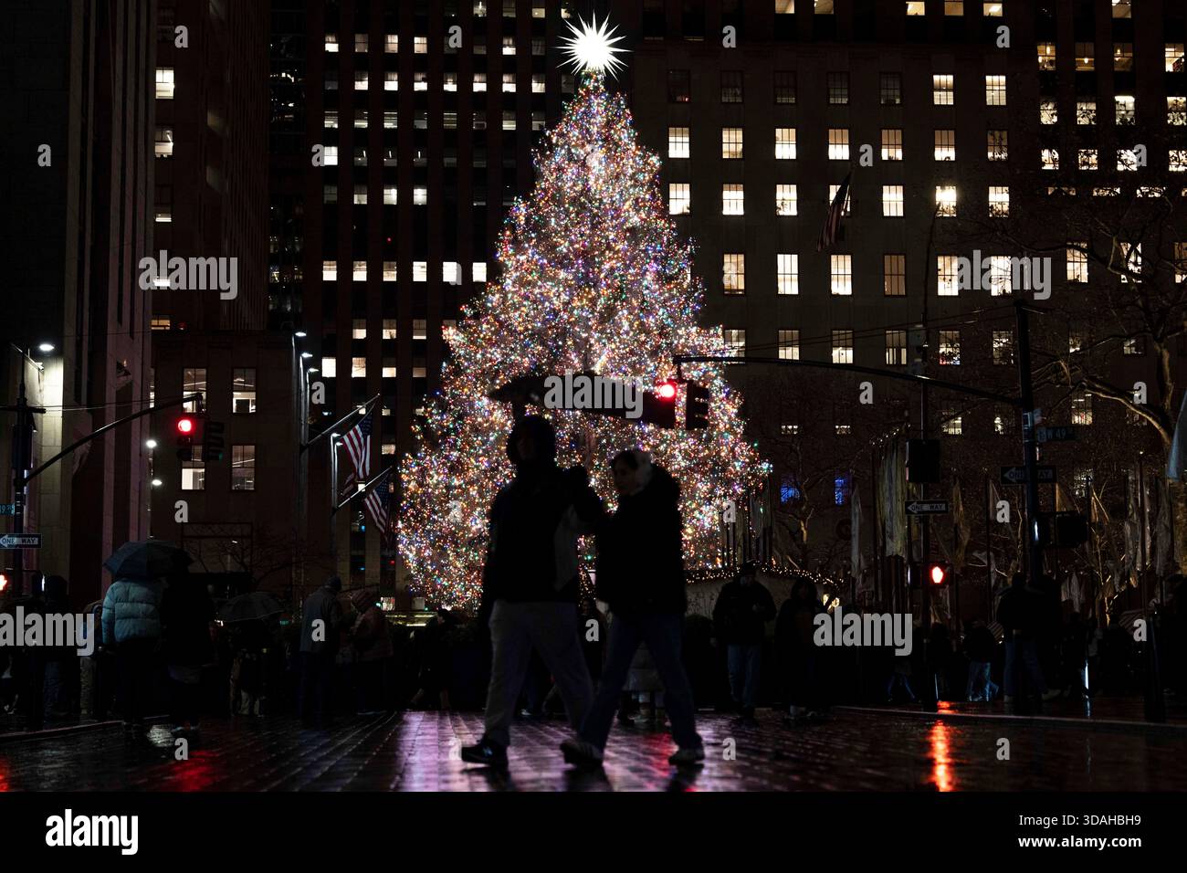 People walk past the Rockefeller Center Christmas tree, Wednesday, Dec ...