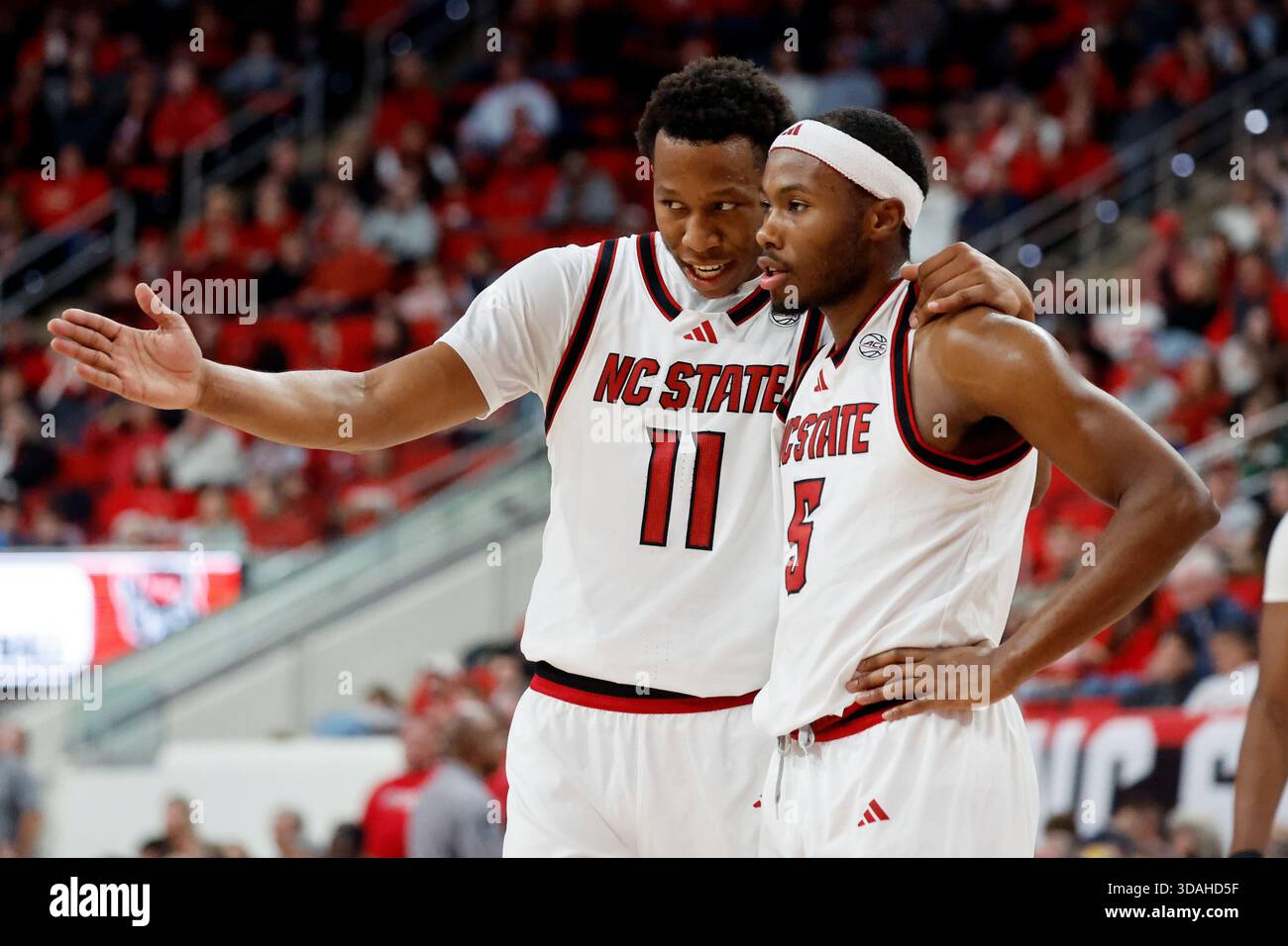 NC State's Quadir Copeland (11) talks with Tre Holloman (5) during the ...