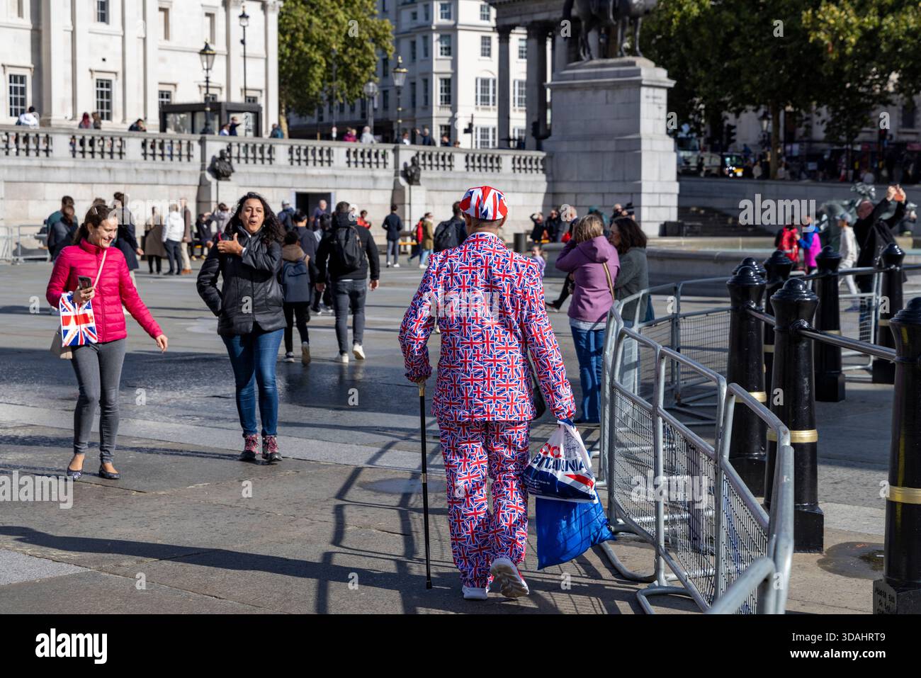 British man wearing Union Jack suit clothing walking through Trafalgar ...