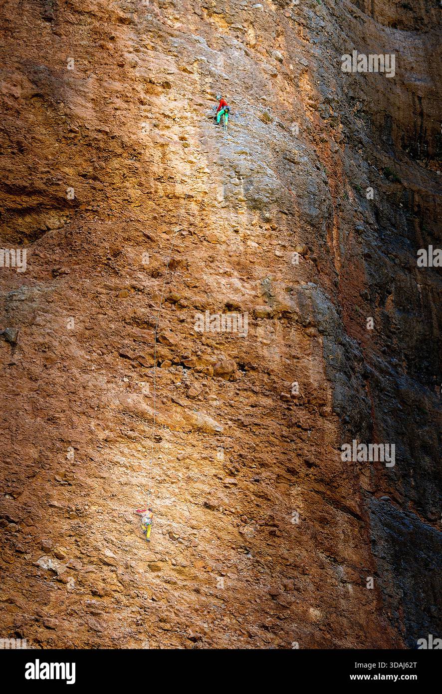 Conceptual shot showing the immense scale of a cliff compared to tiny ...