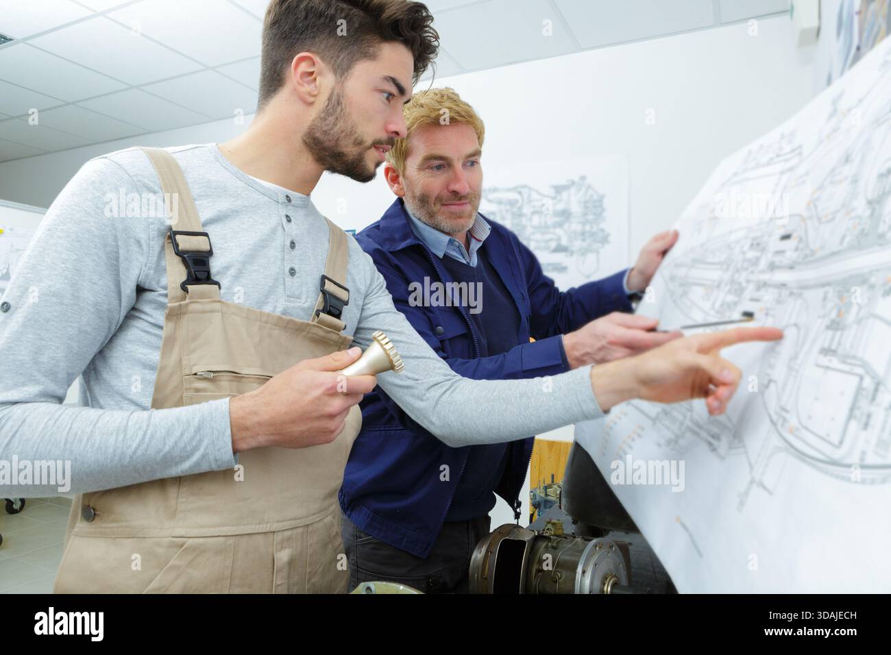 two male designers discussing technical drawing Stock Photo - Alamy
