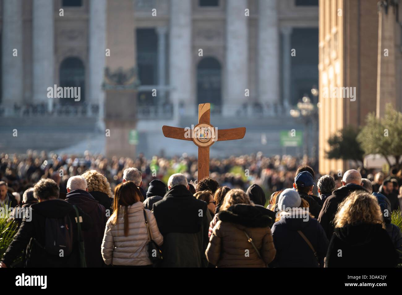 The faithful carry a cross along the pilgrimage route to the Holy Door ...