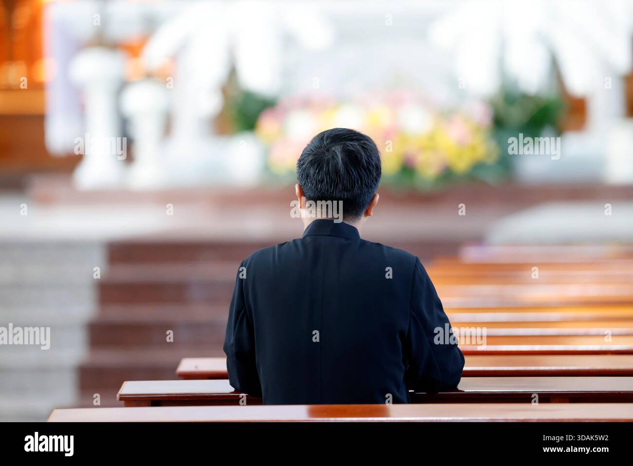 An Hoi catholic church. Back view of a man praying in church. Can Tho ...