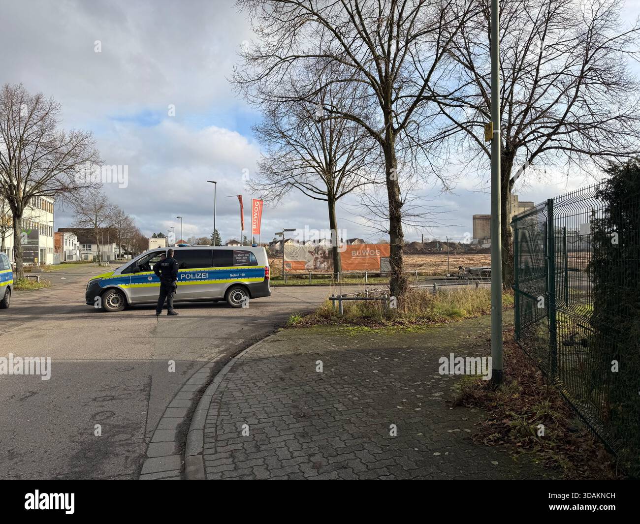 Hanau, Germany. 11th Dec, 2025. Police officers stand at the cordoned ...