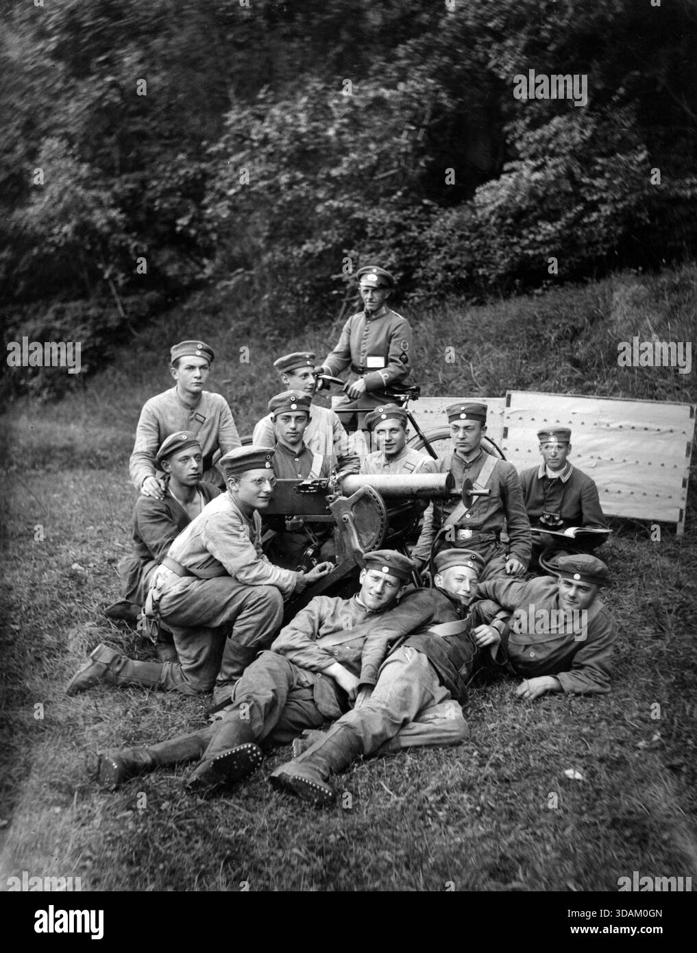 A group of German soldiers pose with a 08/15 machine gun in a meadow ...