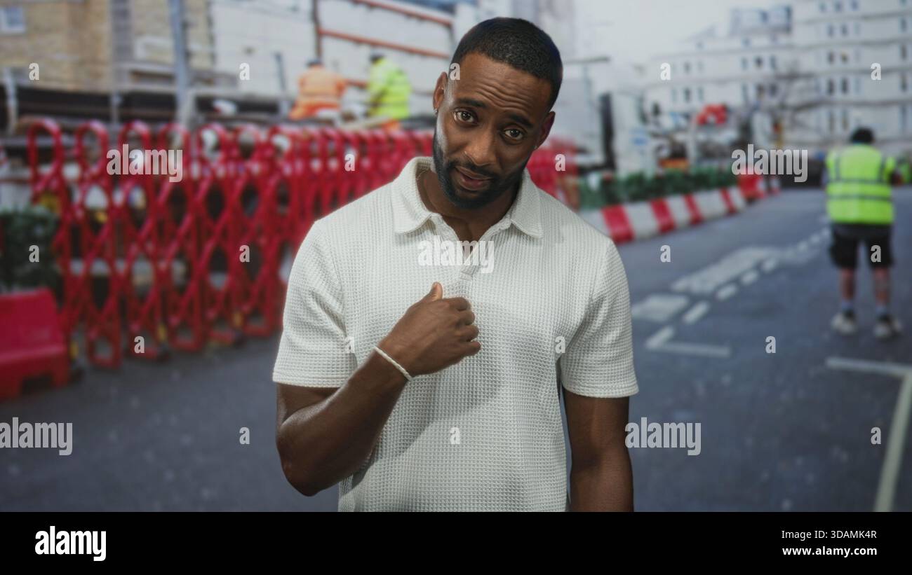 Man pointing index finger in front of red barrier on a street ...